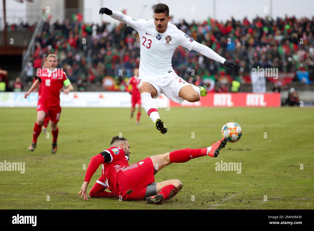 Portugal's Andre Silva, top, jumps over Luxembourg's Maxime Chanot ...