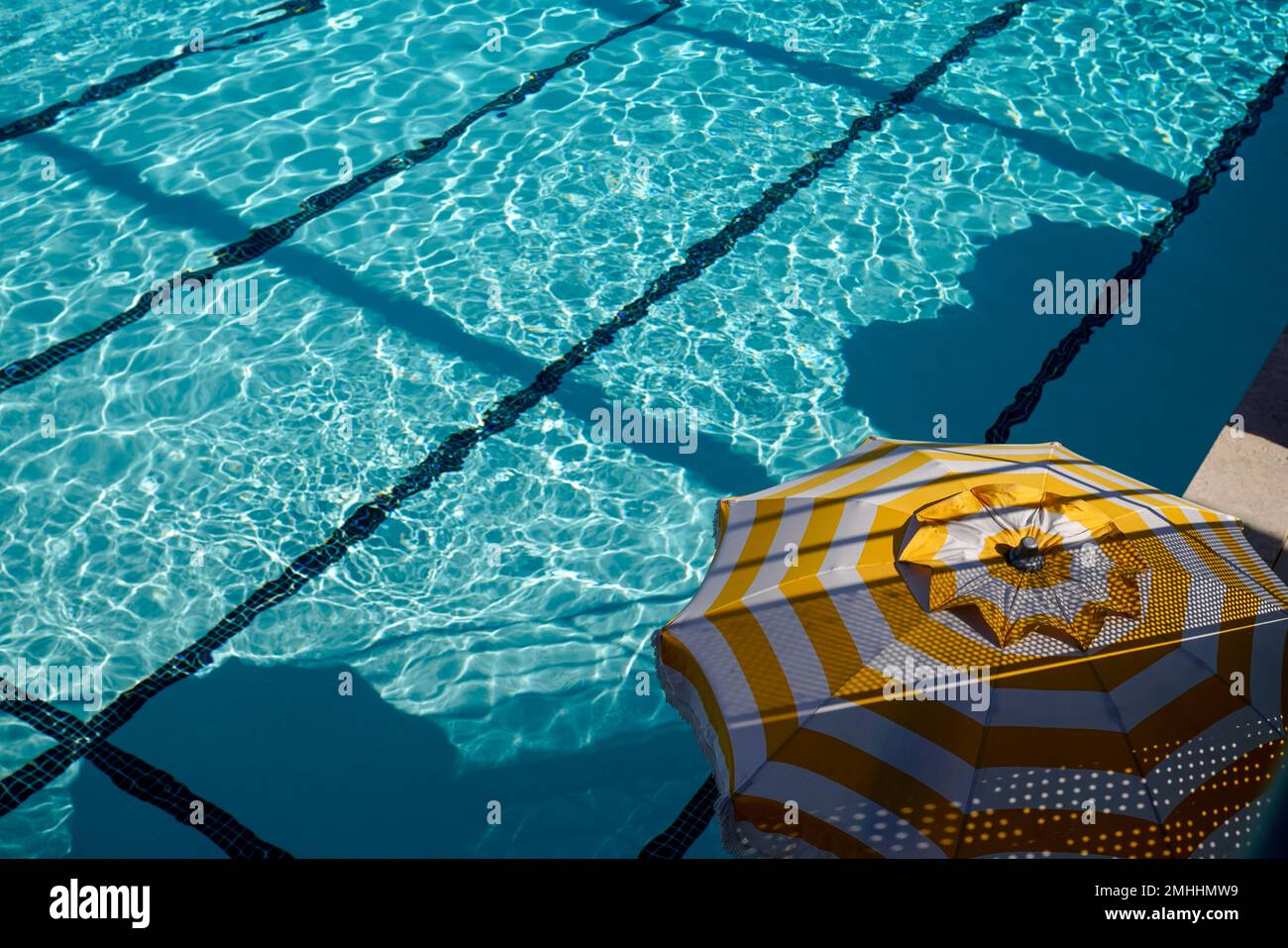 Top view swimming pool with yellow parasol beach umbrella in summer ...