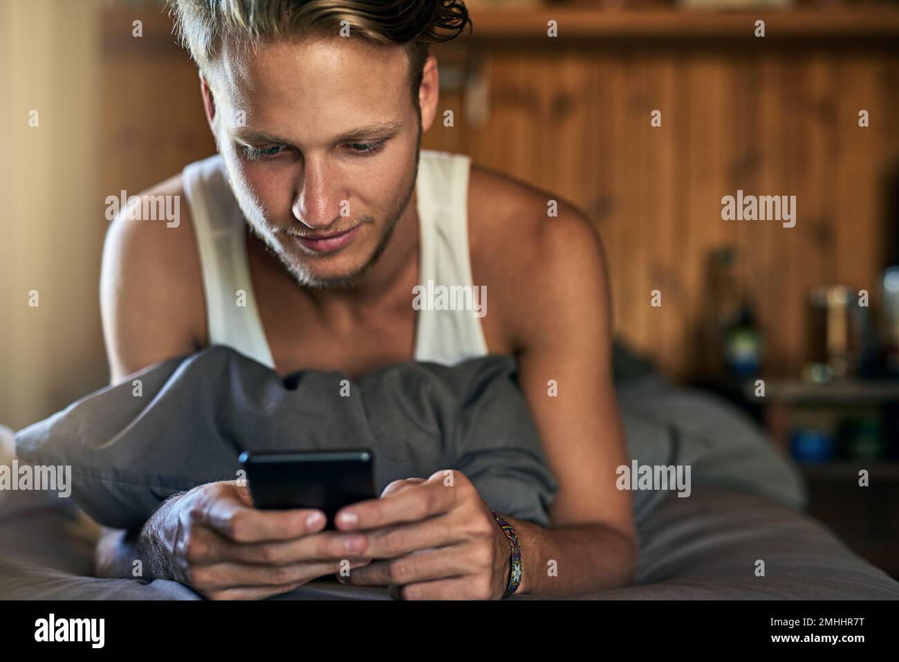 Sending out a few good morning texts. a young man texting on his ...