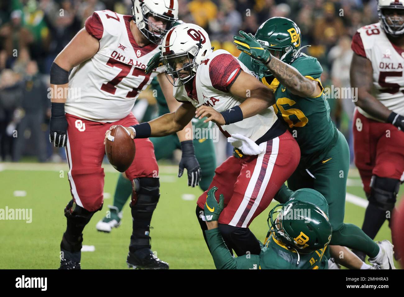 Oklahoma quarterback Jalen Hurts, center, is sacked by Baylor ...