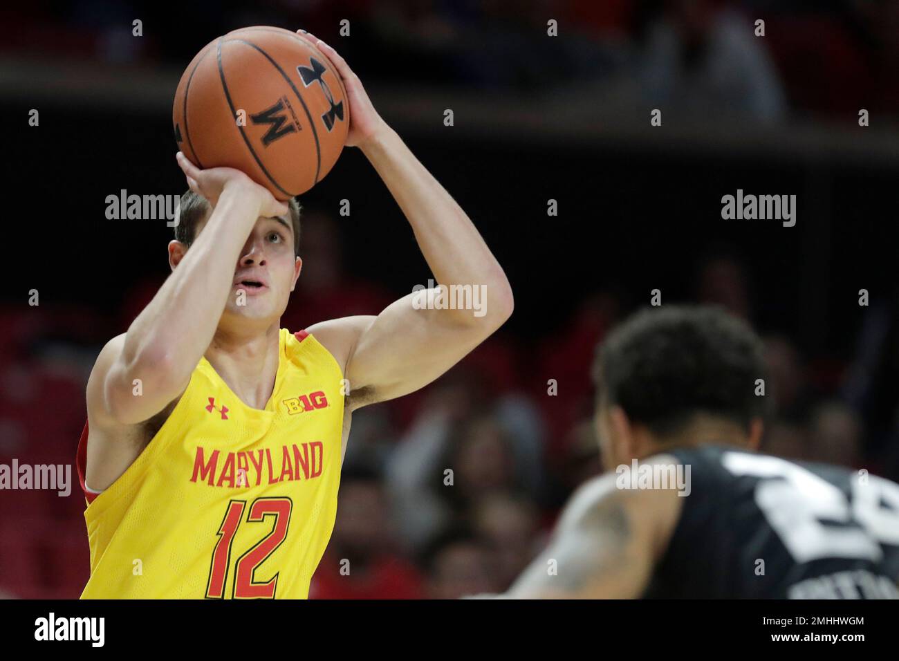 Maryland guard Reese Mona (12) shoots over Oakland guard Kenny Pittman ...