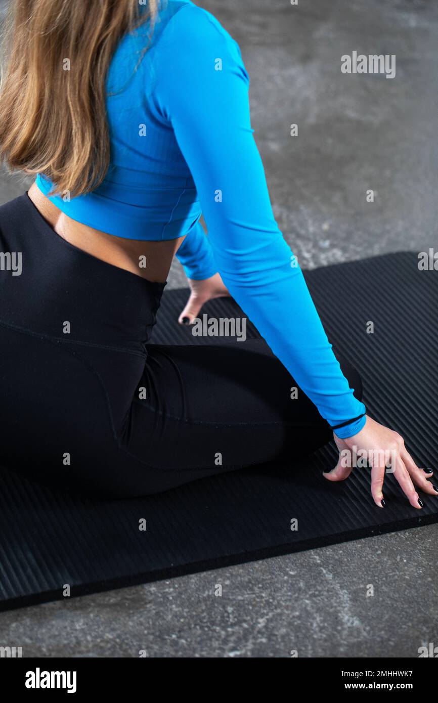 A young athlete pulls the muscles of her legs, the pose of a swan. The ...