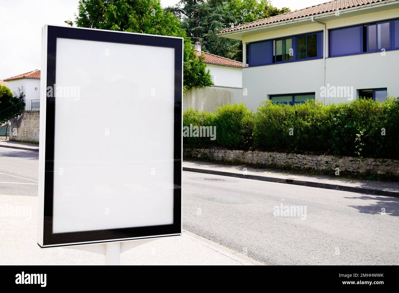 Vertical blank white billboard in city street with town background ...