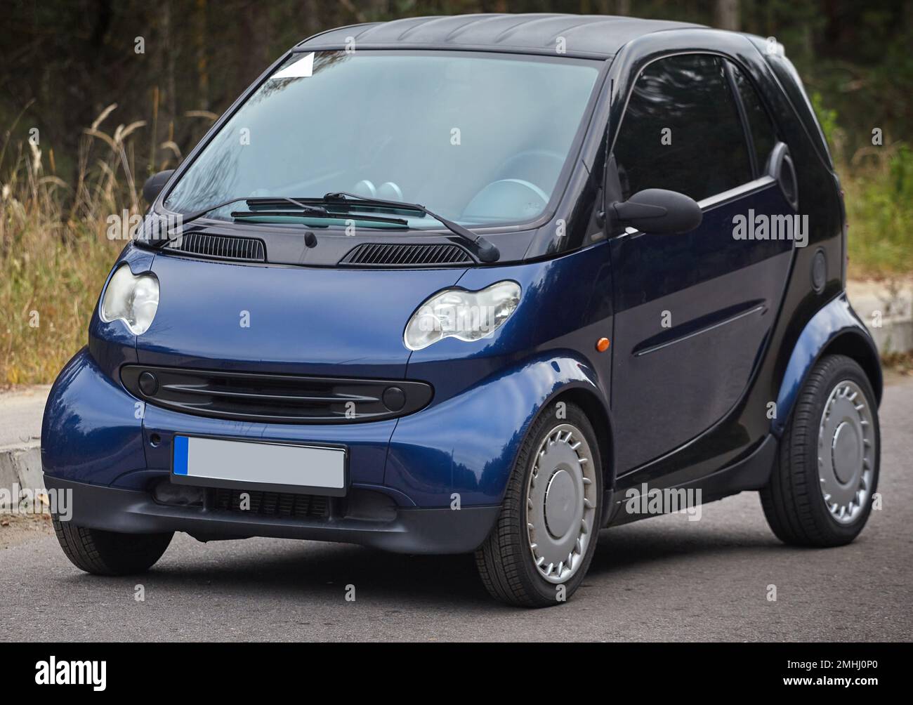 Little blue car driving on the road, modern city car background Stock ...