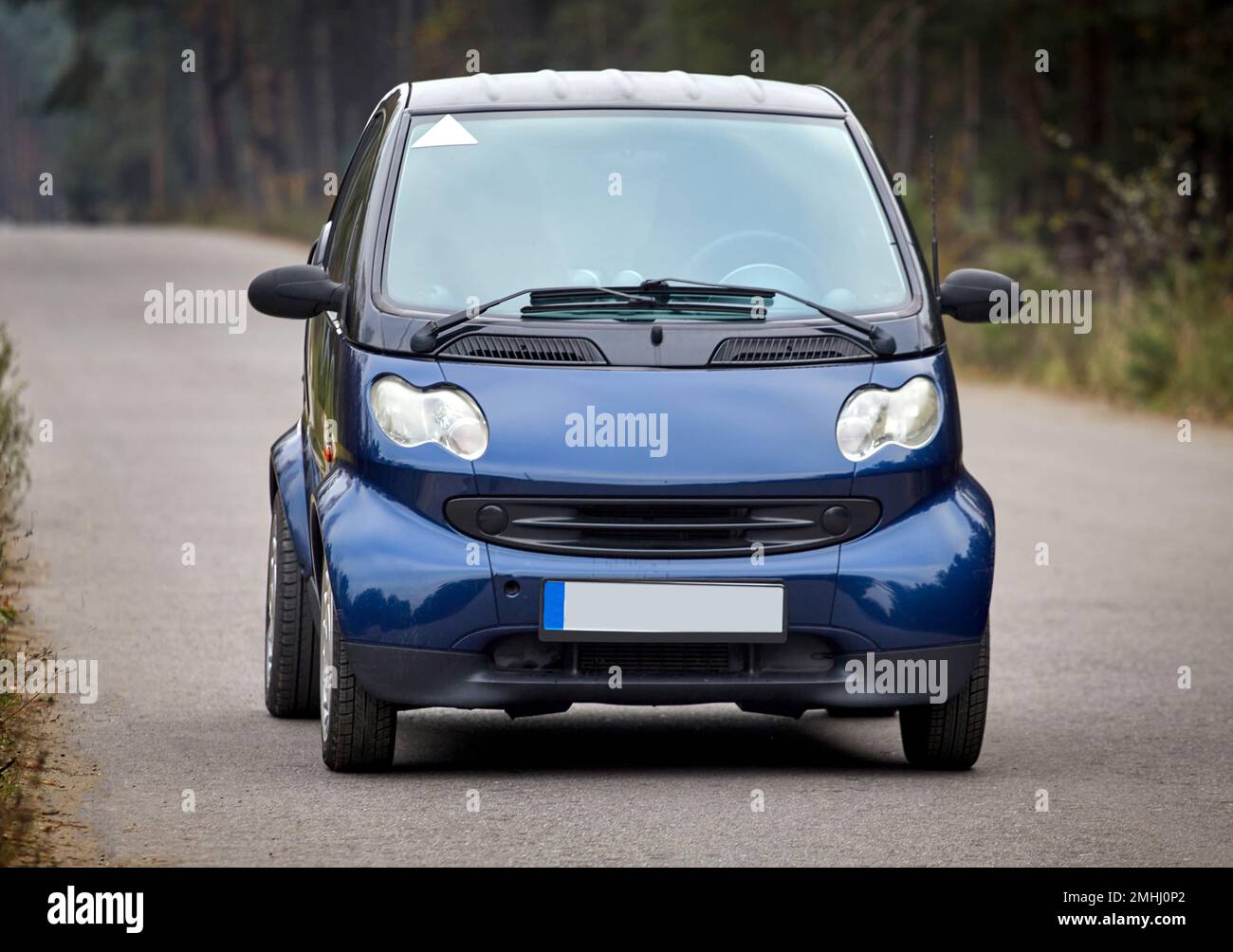 Little blue car driving on the road, modern city car background Stock ...