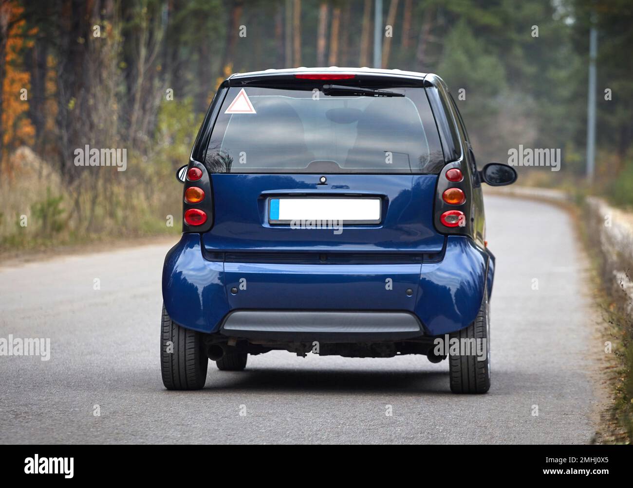 Little blue car driving on the road, modern city car background Stock ...