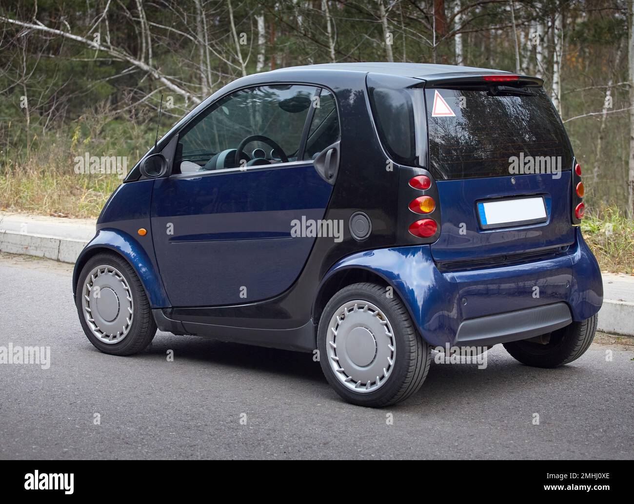 Little blue car driving on the road, modern city car background Stock ...