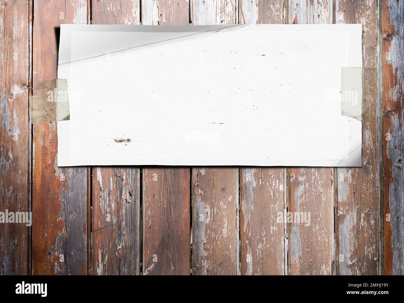 white sheet of old paper hanging on wood plank wall glued with piece of ...