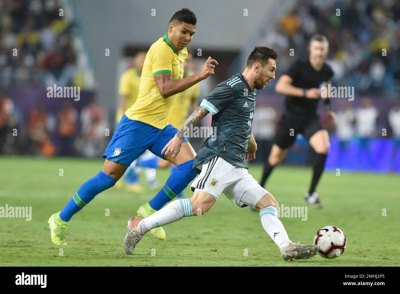 Argentina's Lionel Messi, foreground, controls the ball past Brazil's ...