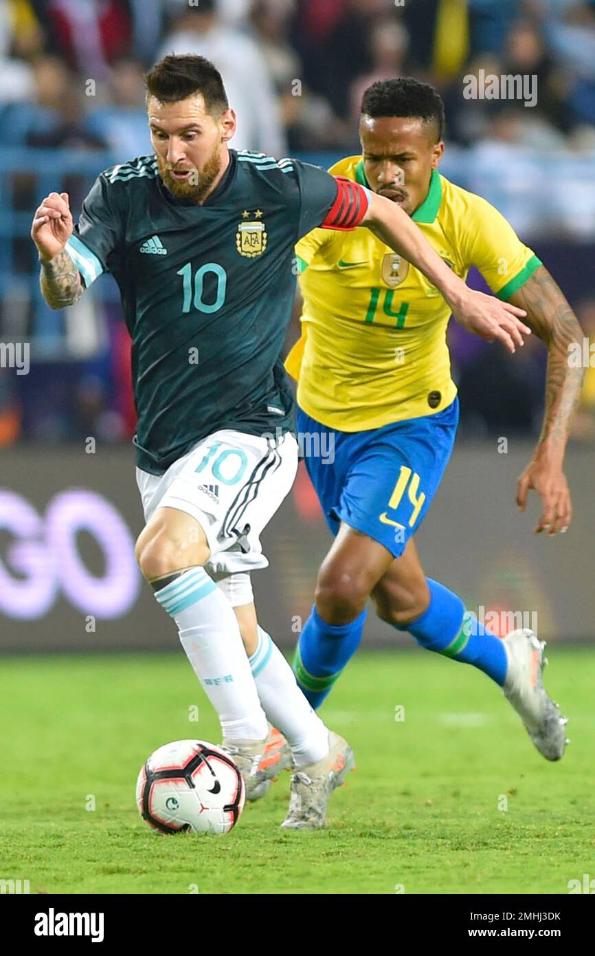 Argentina's Lionel Messi, left, runs with the ball past Brazil's ...