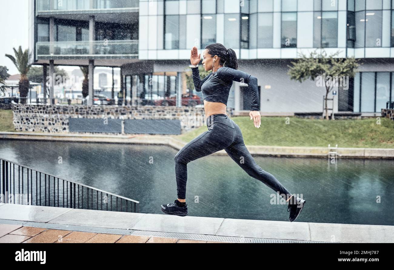 Run, rain and black woman with fitness, workout and training for ...