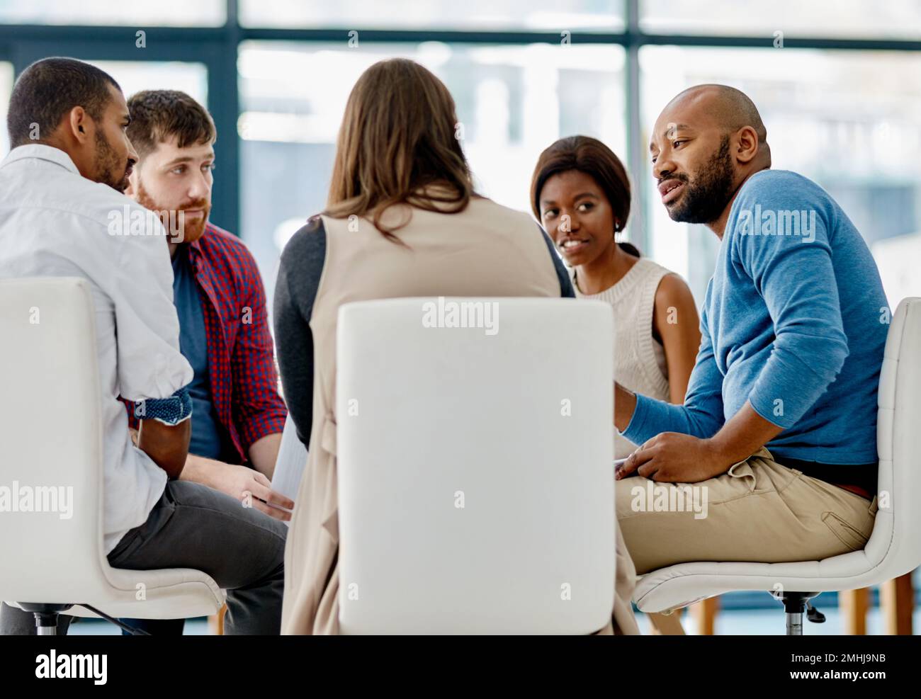Meetings facilitate communication. a group of young designers sitting ...