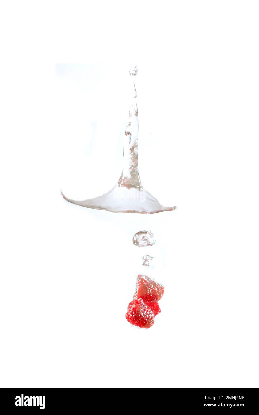 Raspberry falls deeply under water with a big splash Stock Photo - Alamy