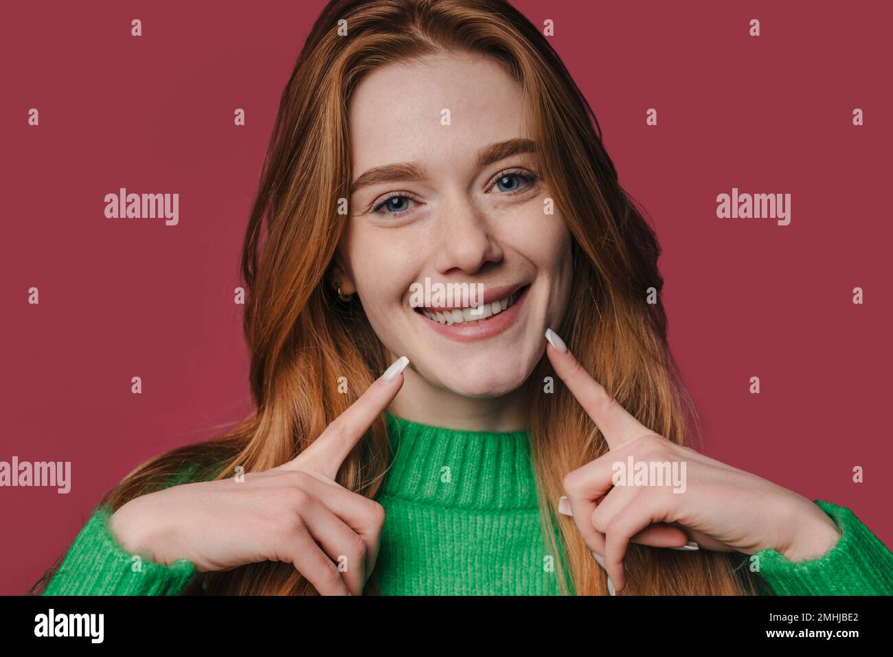 Read headed woman with freckles on her face standing over crimson ...