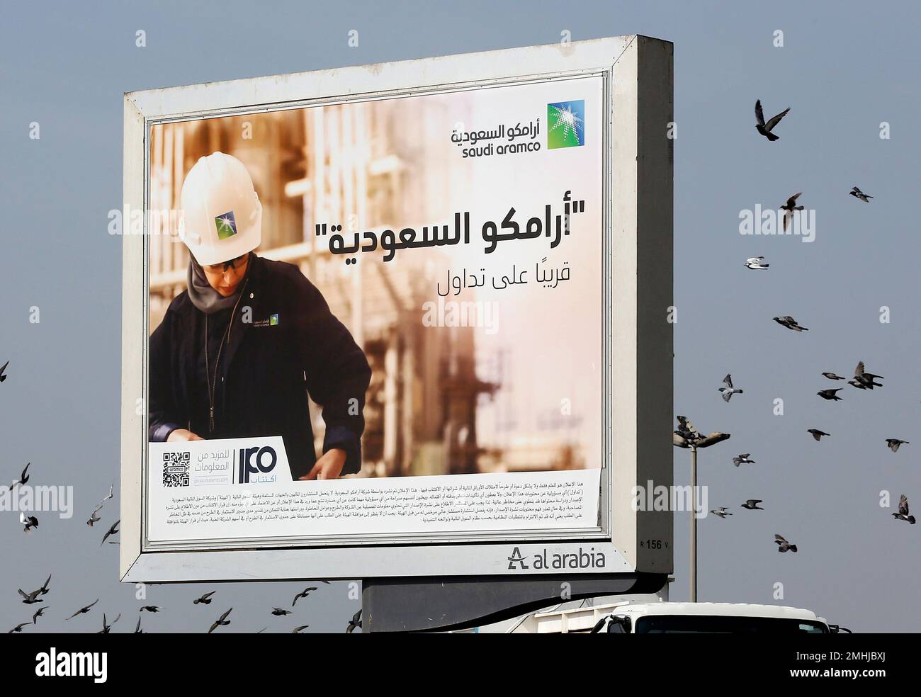 Birds fly over a billboard advertisement for Saudi Arabia's state-owned ...