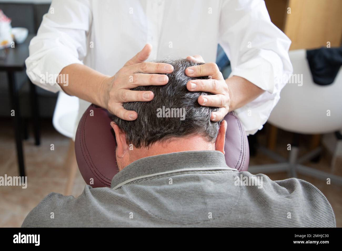 Massage Therapist Man Massaging Male Head Skull Sitting On Massage Seated By Woman Specialist On