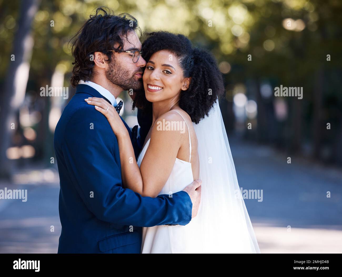 Interracial wedding and couple kiss portrait at romantic outdoor ...