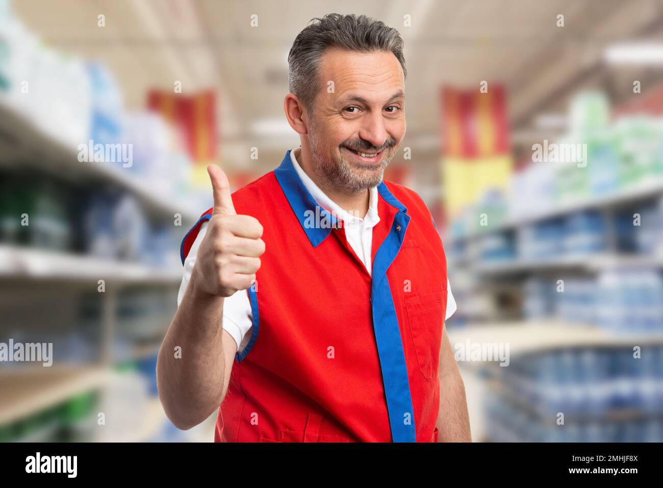 Happy supermarket worker showing thumbs-up sign as good concept Stock ...