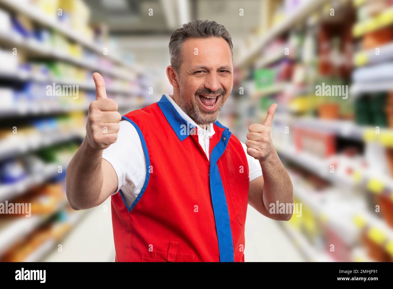 Positive seller man making thumbs-up gesture with both hands as happy ...