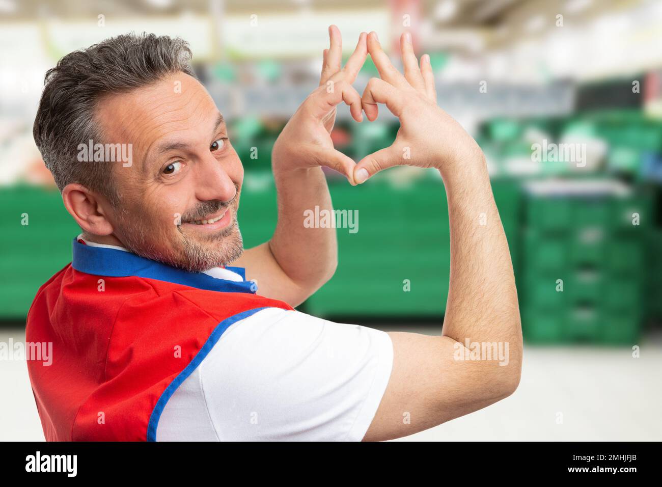 Positive worker man showing heart shape with fingers a happy workday ...
