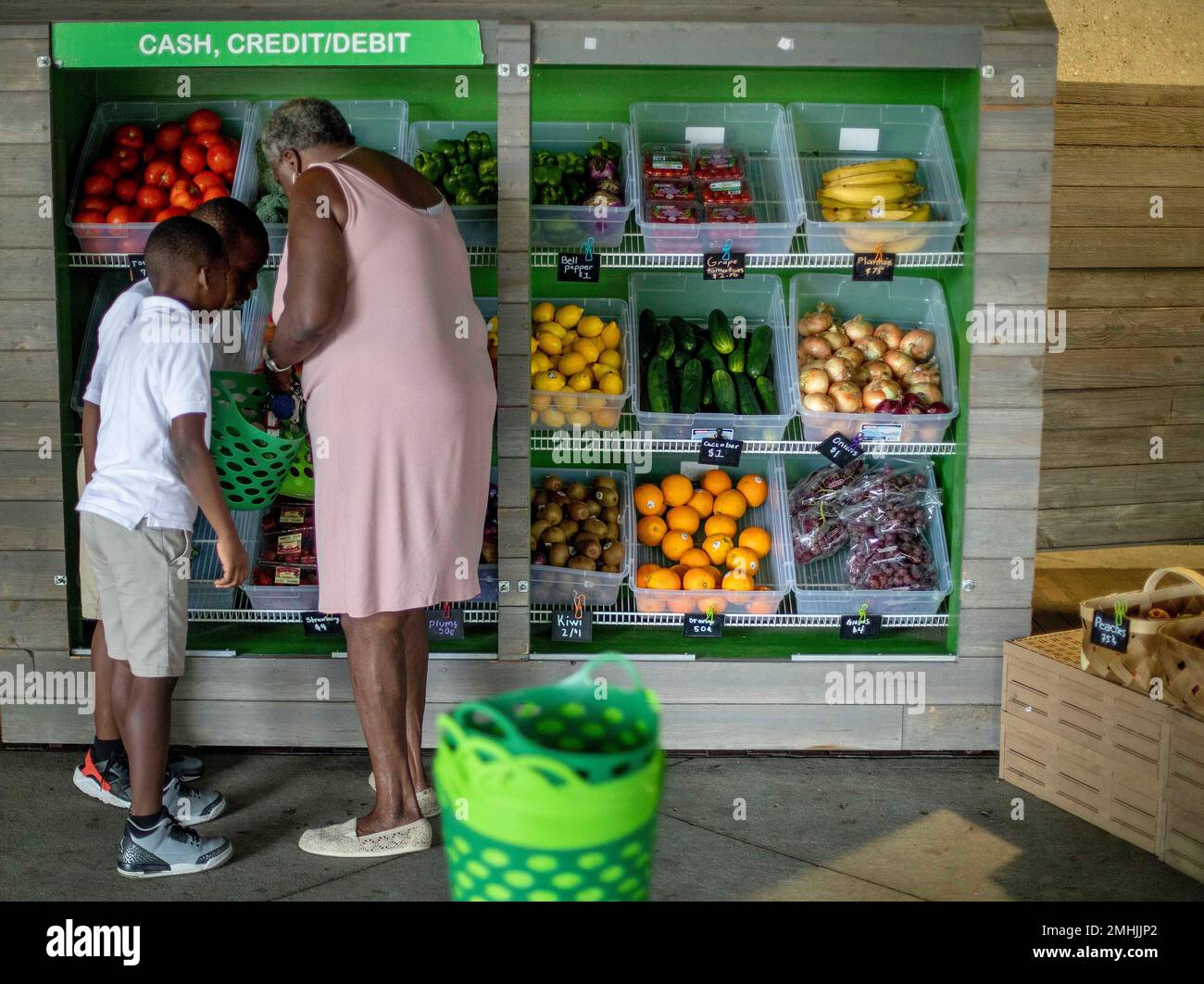 Shoppers pick fruits and vegetables at a produce stand at a metro ...