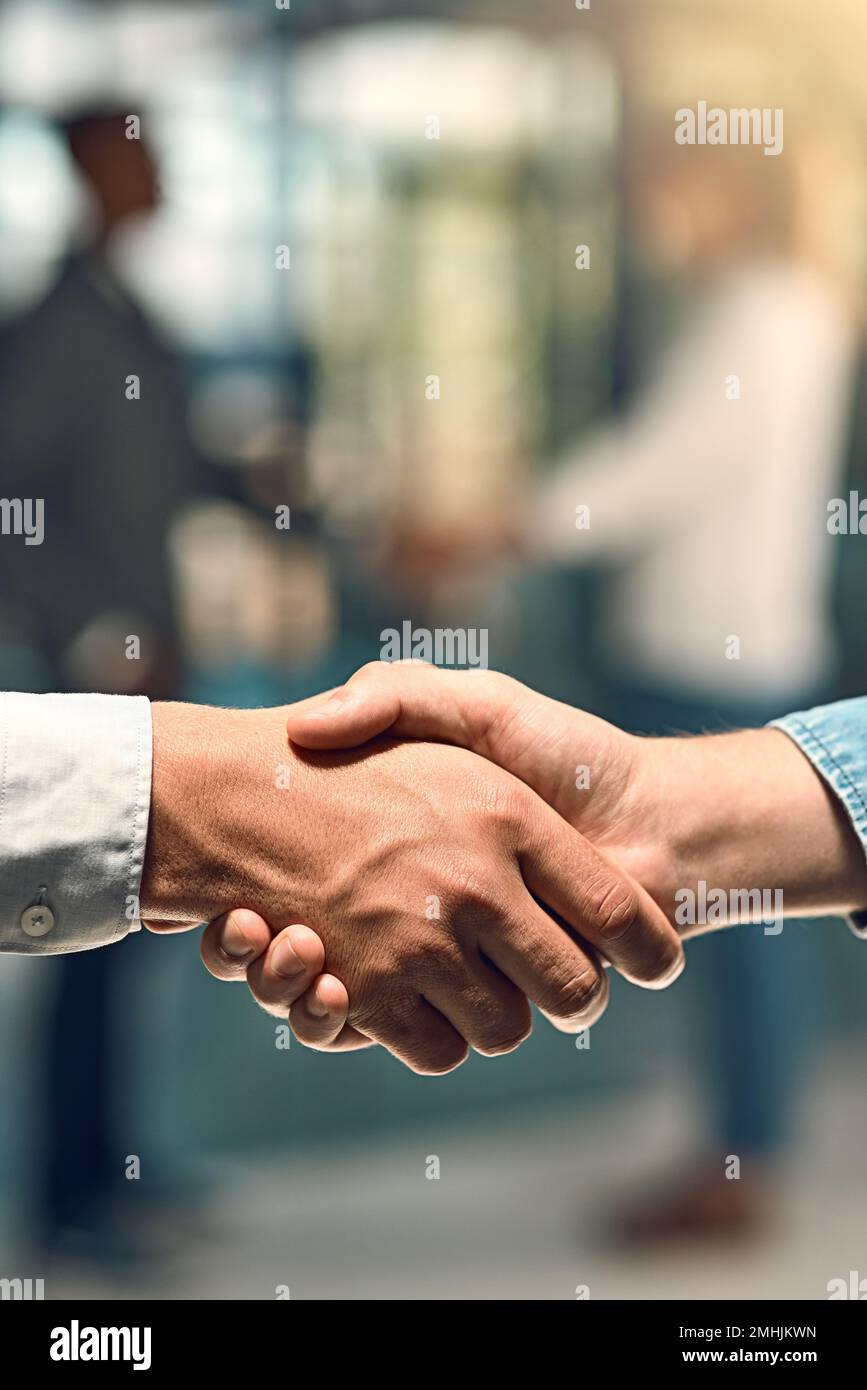 In it to win it. two unidentifiable young business partners shaking ...