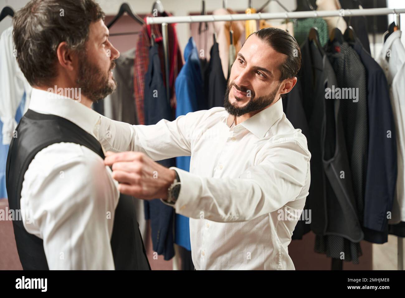 Pleased tailor measuring chest width of customer Stock Photo - Alamy