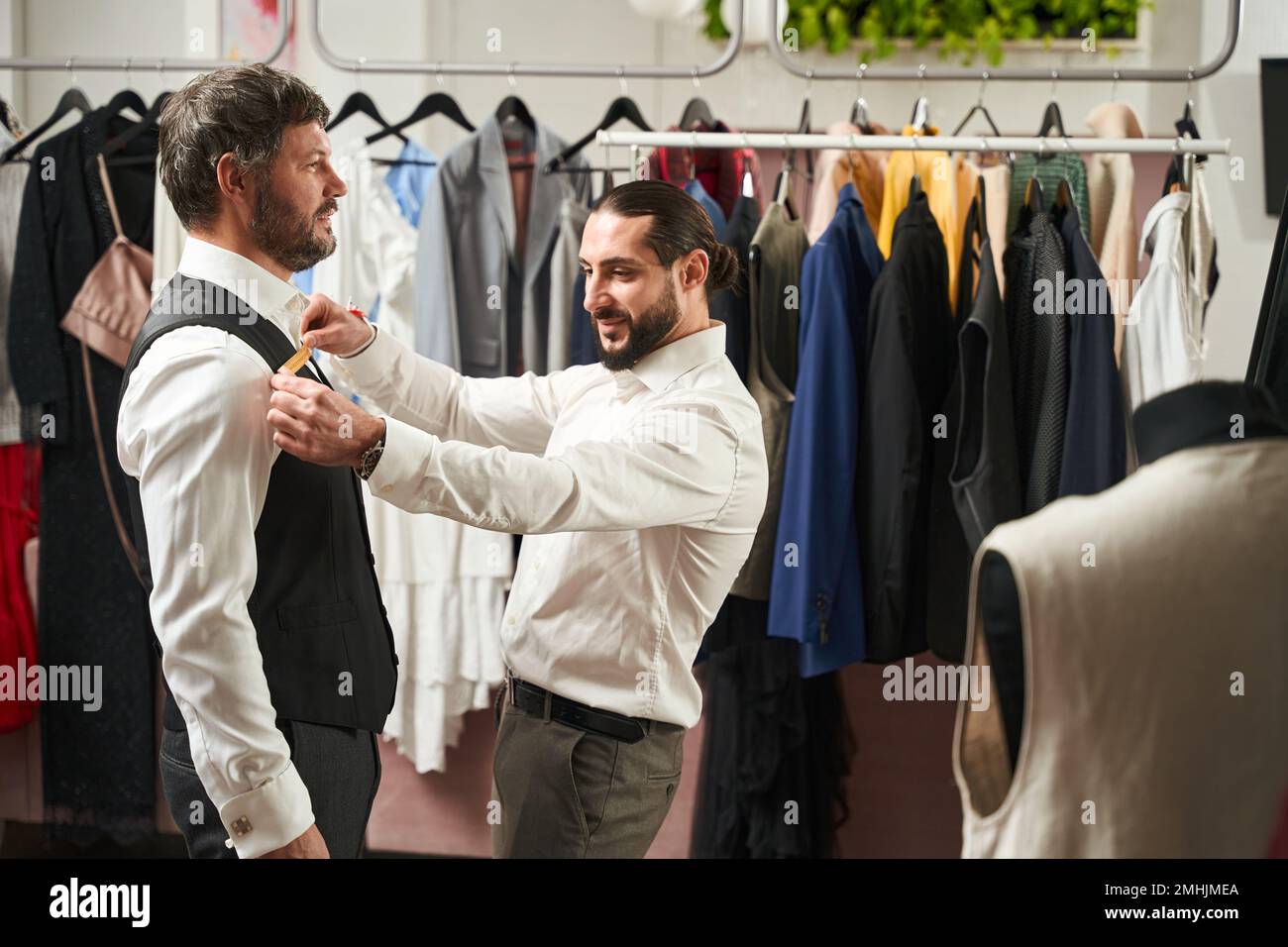 Clothier taking client body measurements in atelier Stock Photo - Alamy