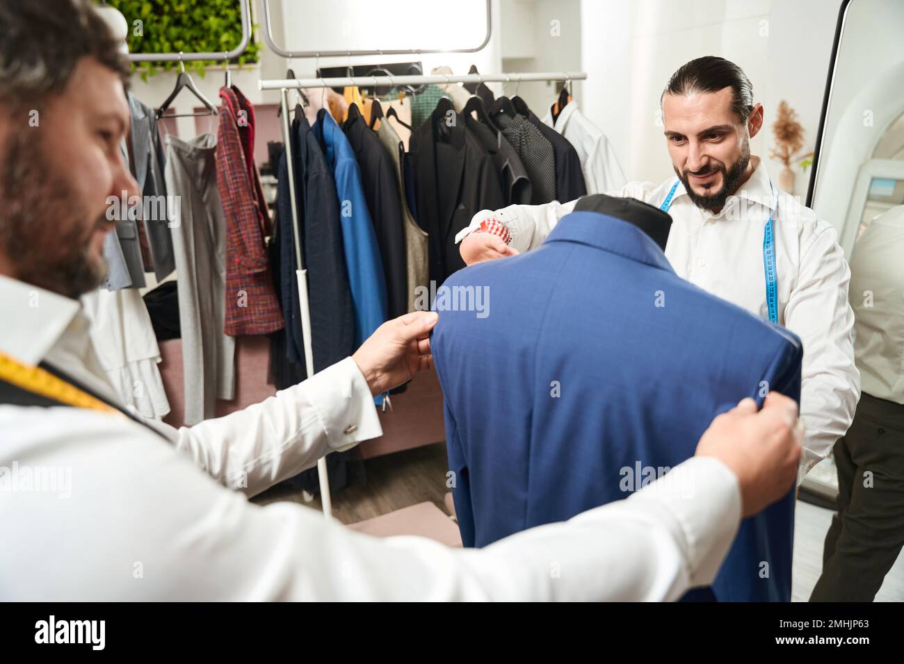 Two tailors involved in custom-making client suit Stock Photo - Alamy