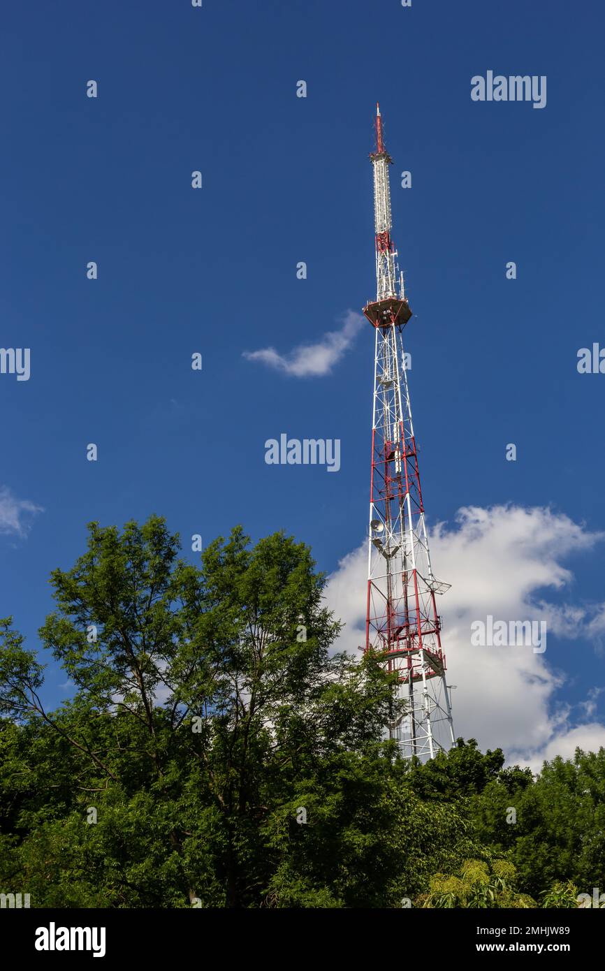 Telecommunication tower for mobile phone with antennas over a blue sky. Distribution function of ...