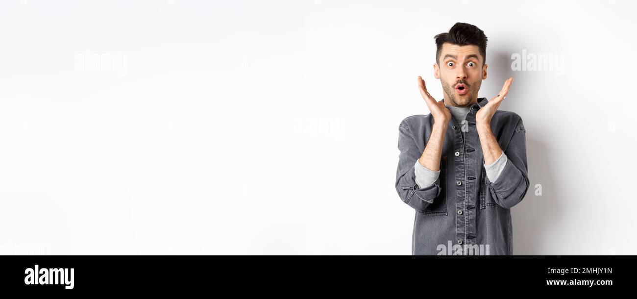 Surprised man gasping excited, say wow and look at amazing ...
