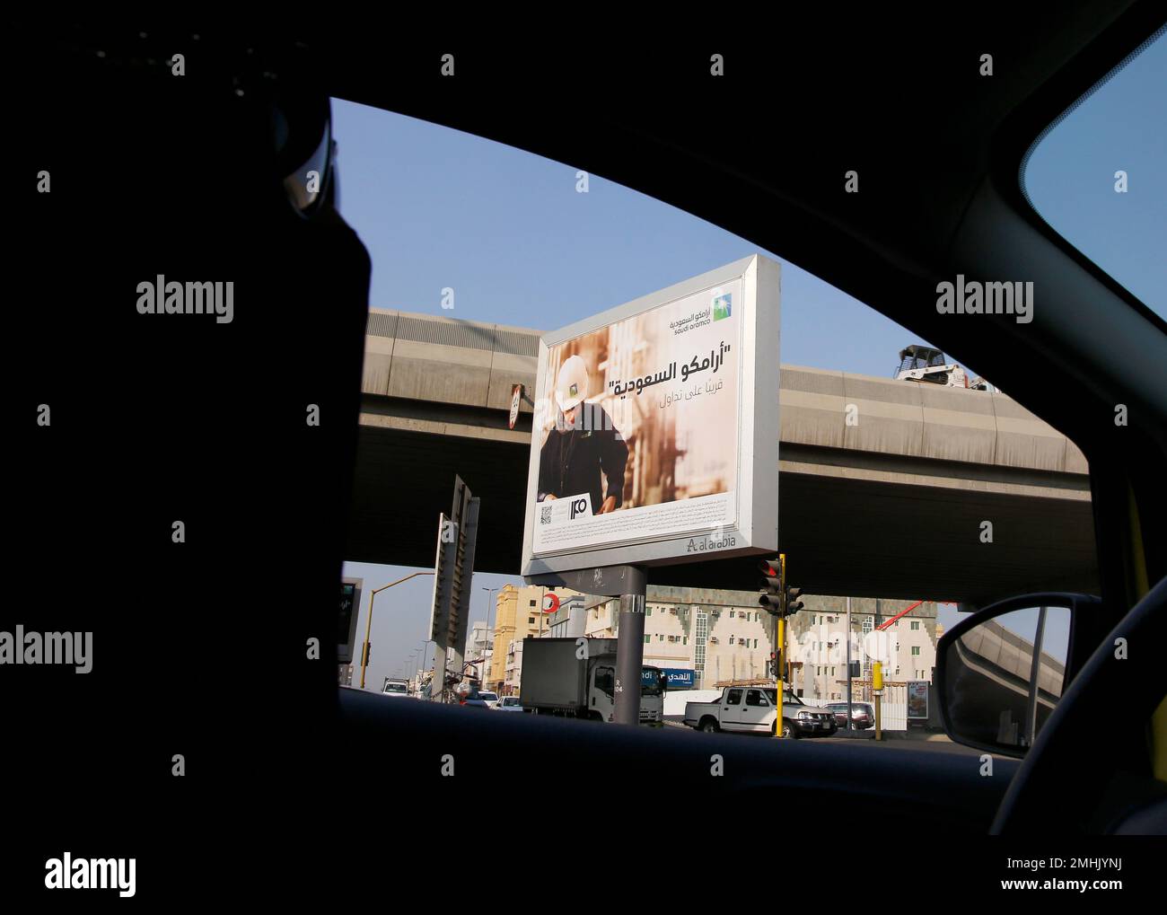 A woman wearing a "Niqab" drives past a billboard displaying an advert ...