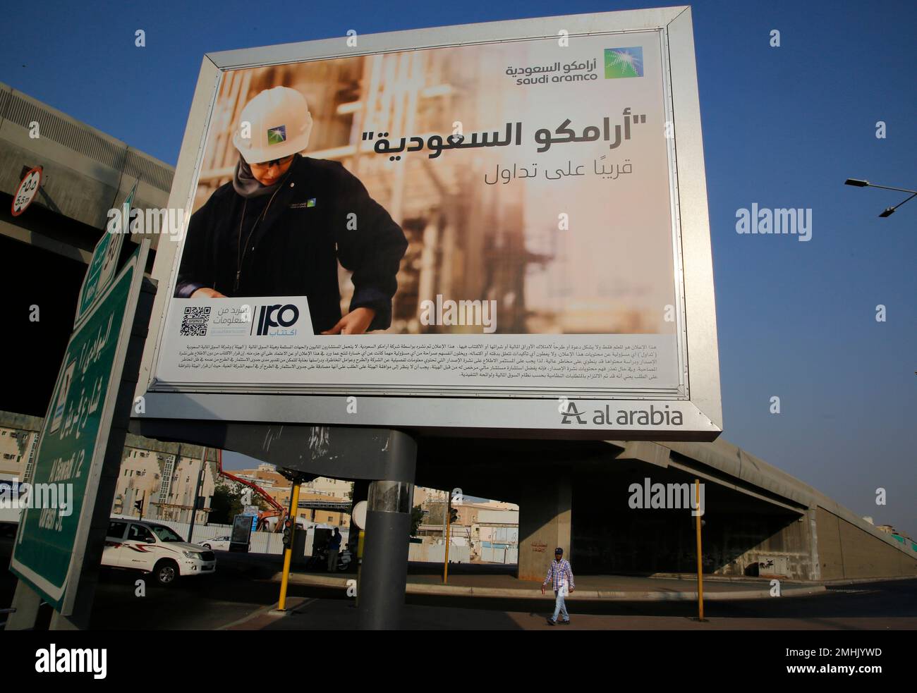 A man walks under a billboard displaying an advertisement for Saudi ...