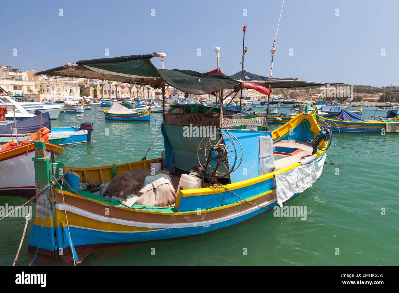 Colorful traditional Maltese fishing boat is moored at Marsaxlokk port ...