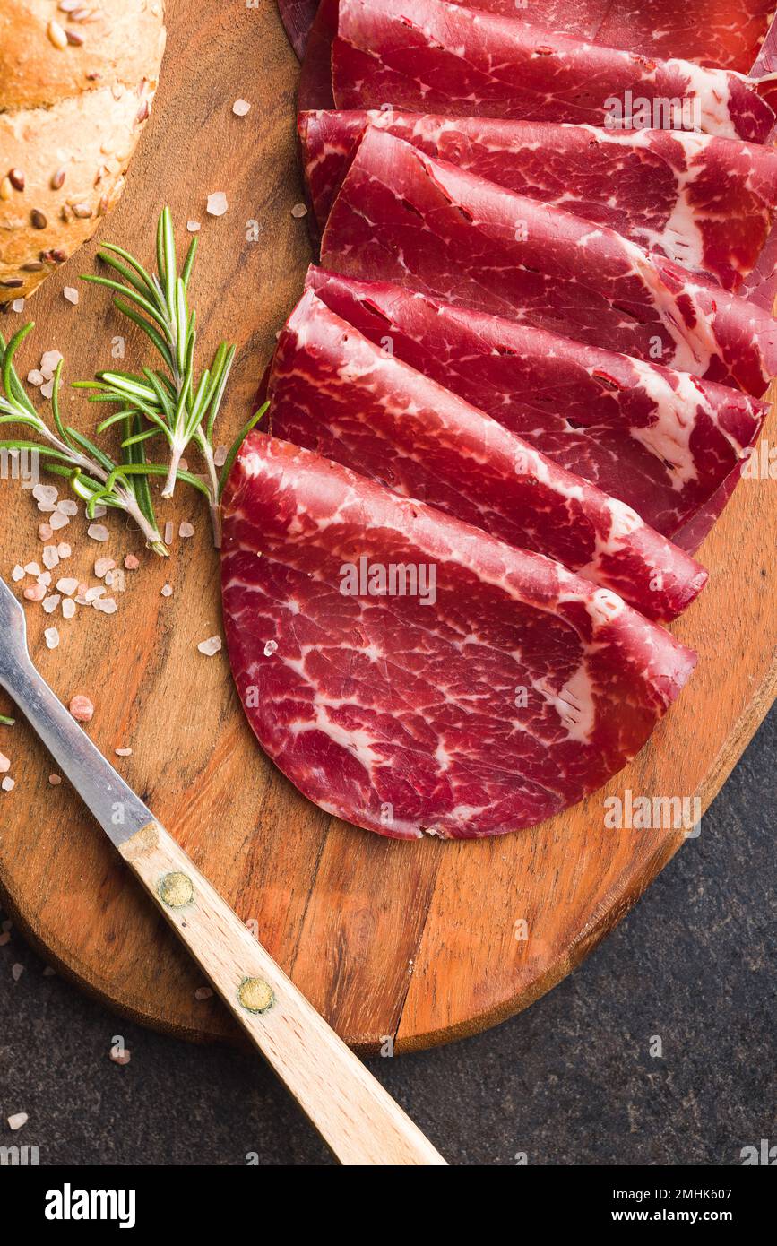 Smoked bresaola. Italian appetizer. Dried beef meat on the cutting ...