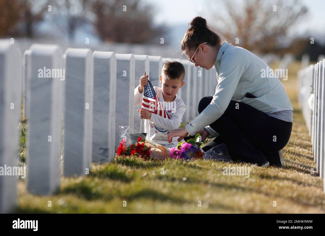 Caleb Vester, left, helps his mother, Lyuba, to place flags and flowers ...