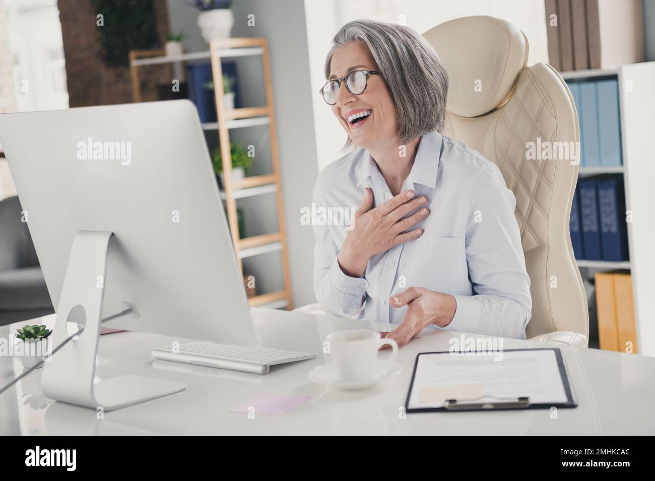 Photo of excited cheerful company owner sit chair speak communicate ...