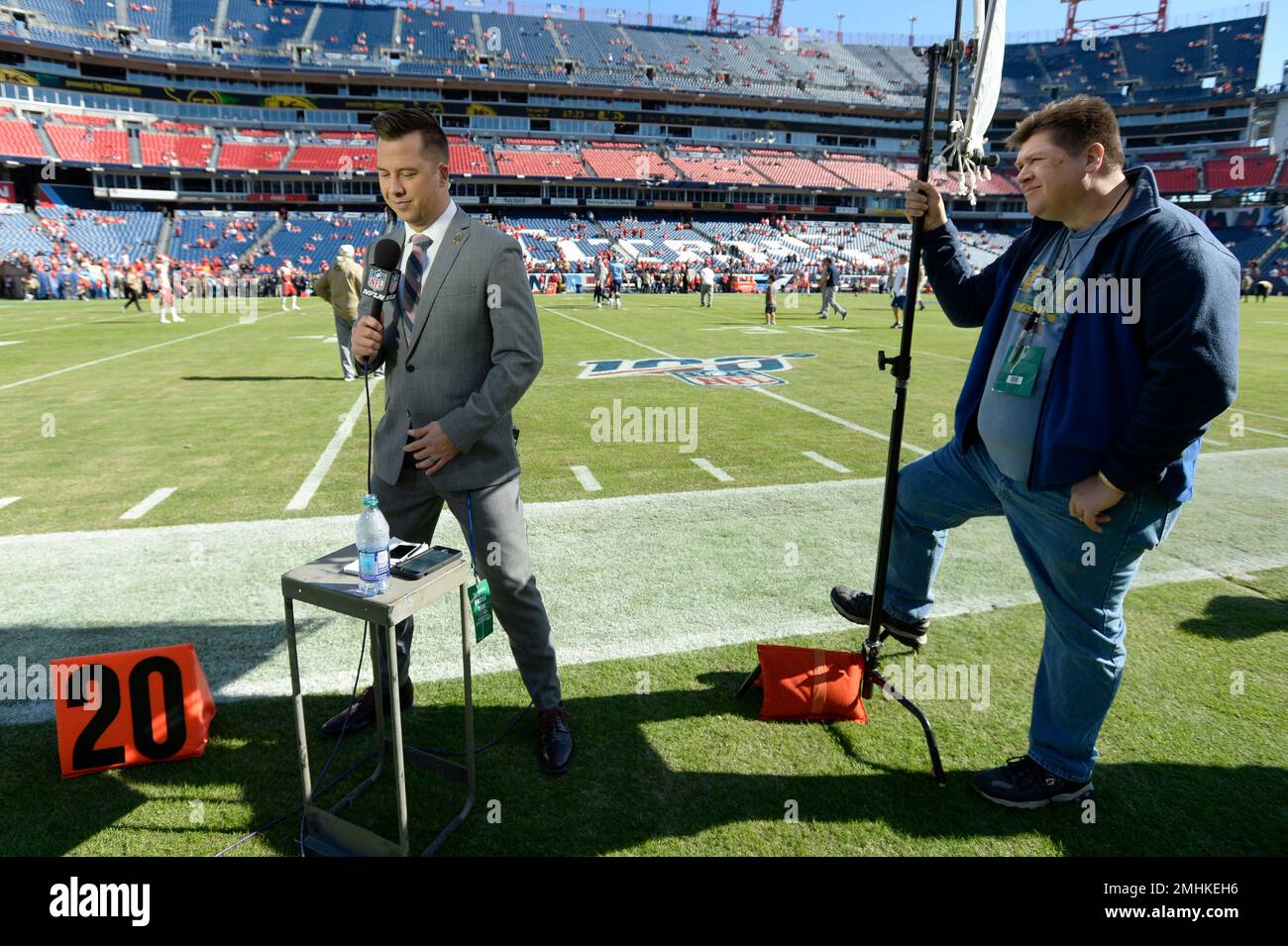 Sideline reporter James Palmer, left, works on the sideline before an ...