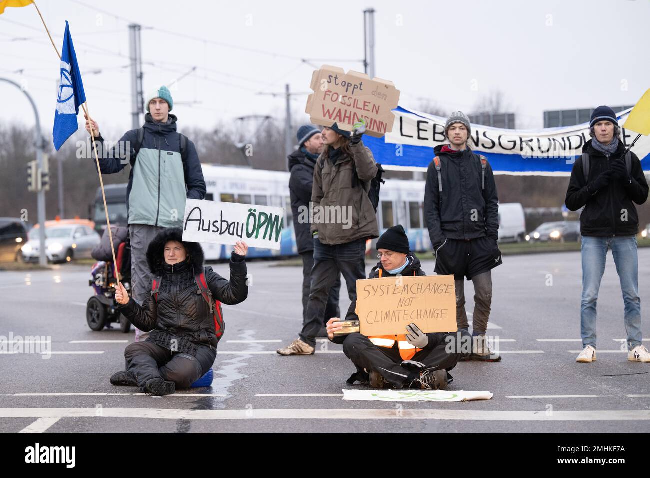 Dresden, Germany. 27th Jan, 2023. Environmental activists sit and stand ...