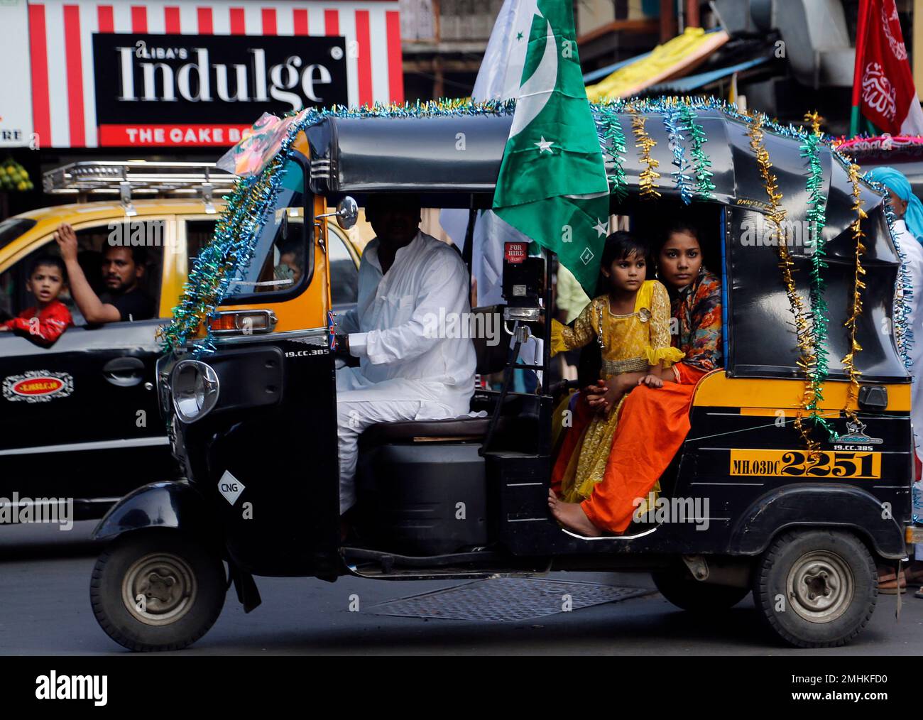 Indian Muslims sit in an auto-rickshaw during a procession to celebrate ...