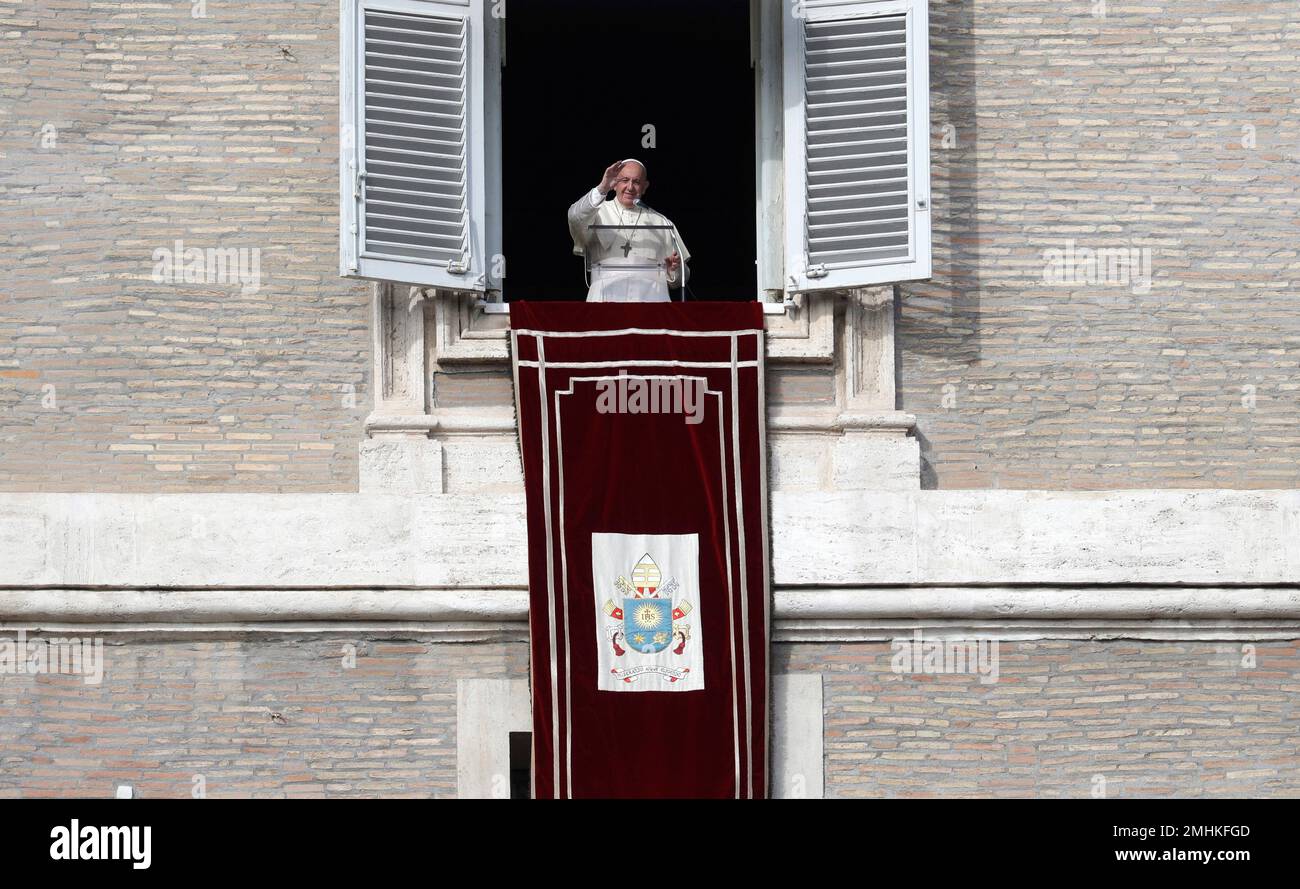 Pope Francis waves during his Angelus prayer from his studio window ...