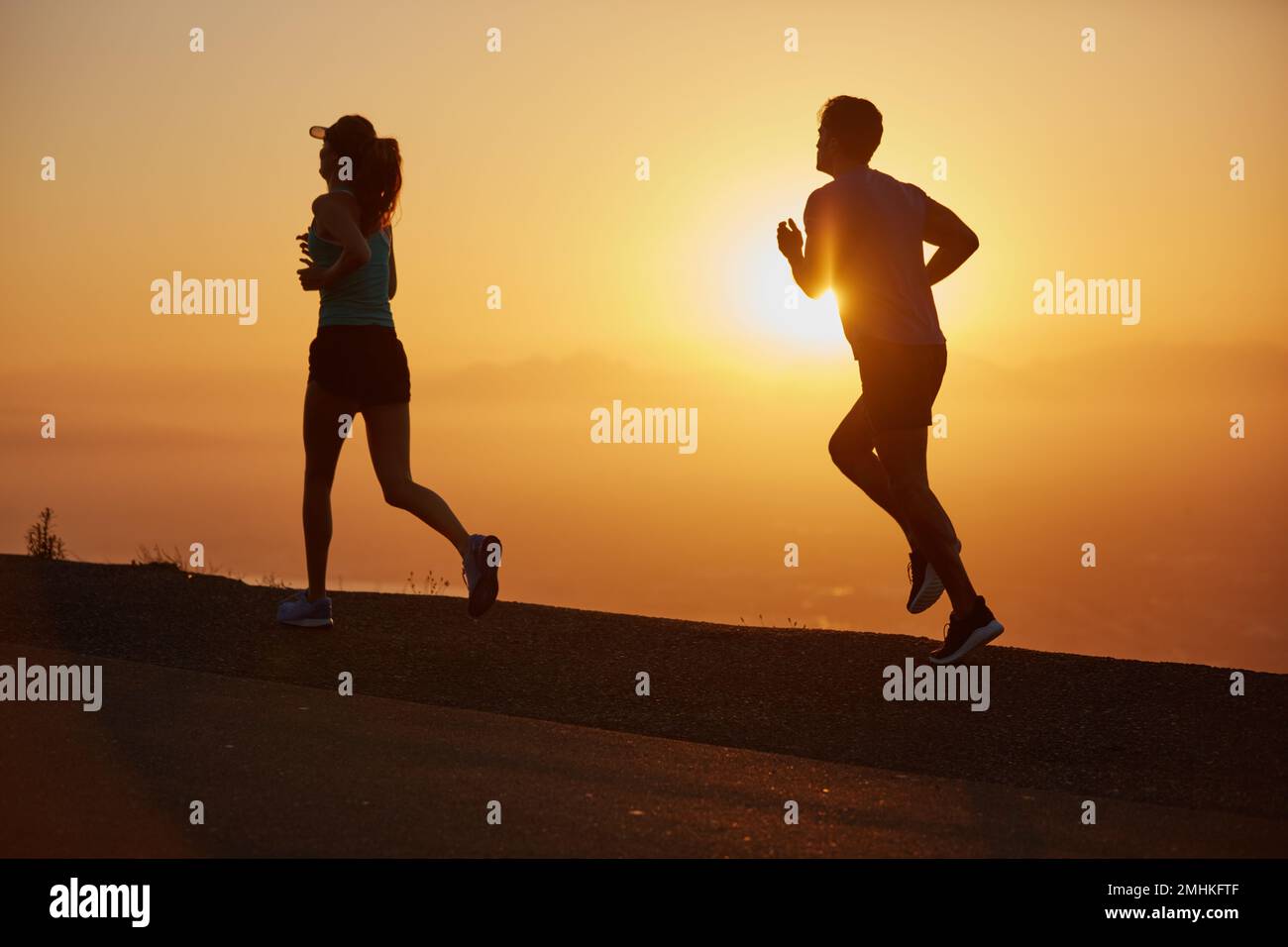 Chasing fitness goals. a silhouetted couple out for a run at sunrise ...