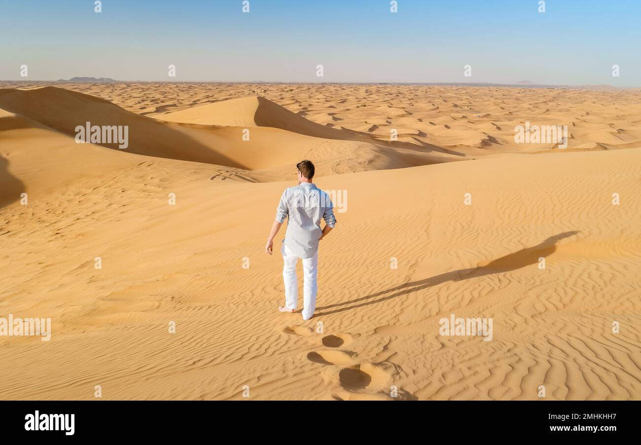 Young men walking in the desert of Dubai, Sand dunes of Dubai United ...