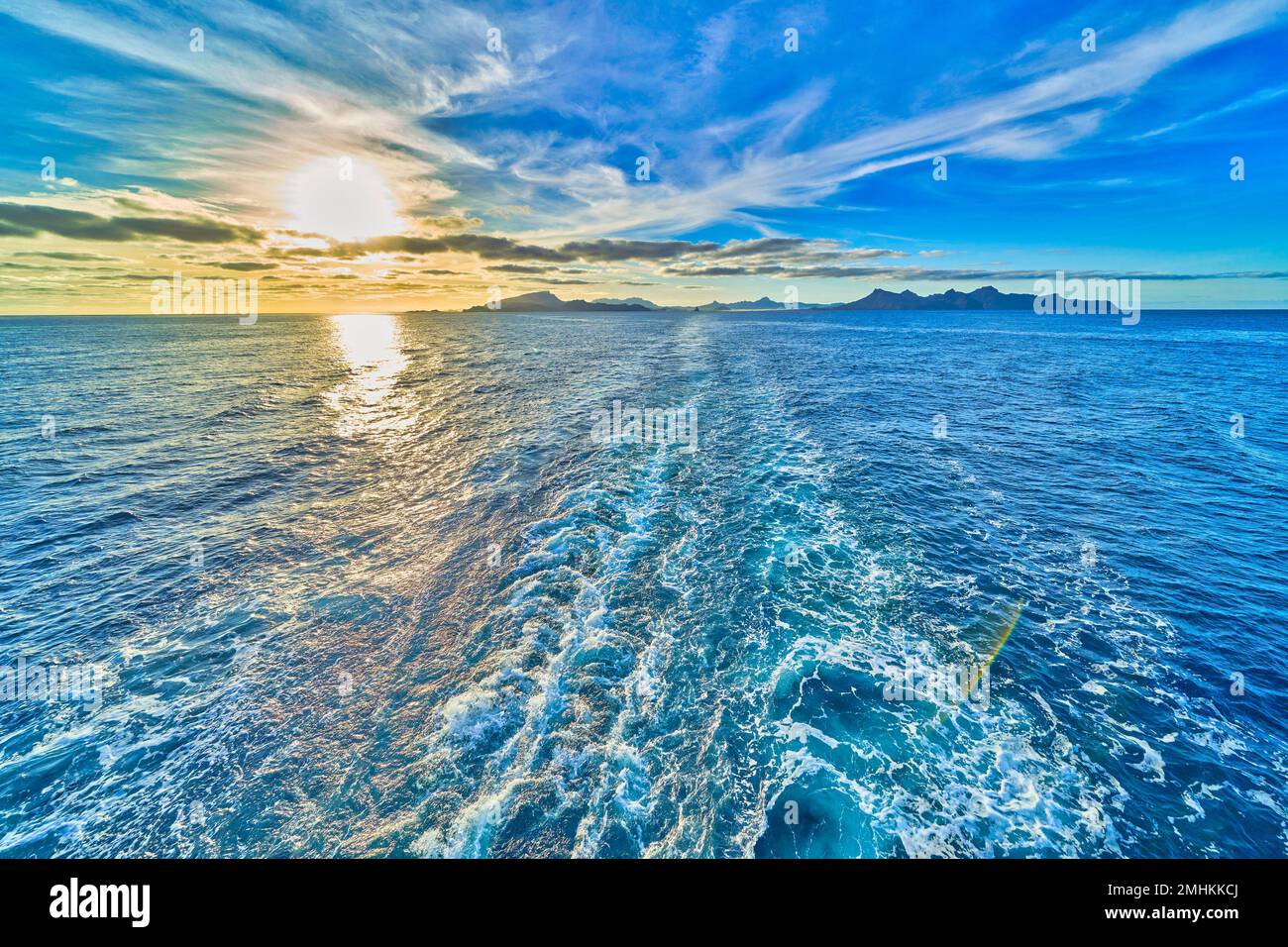 boat trail in water with sunset and cloudscape Stock Photo - Alamy