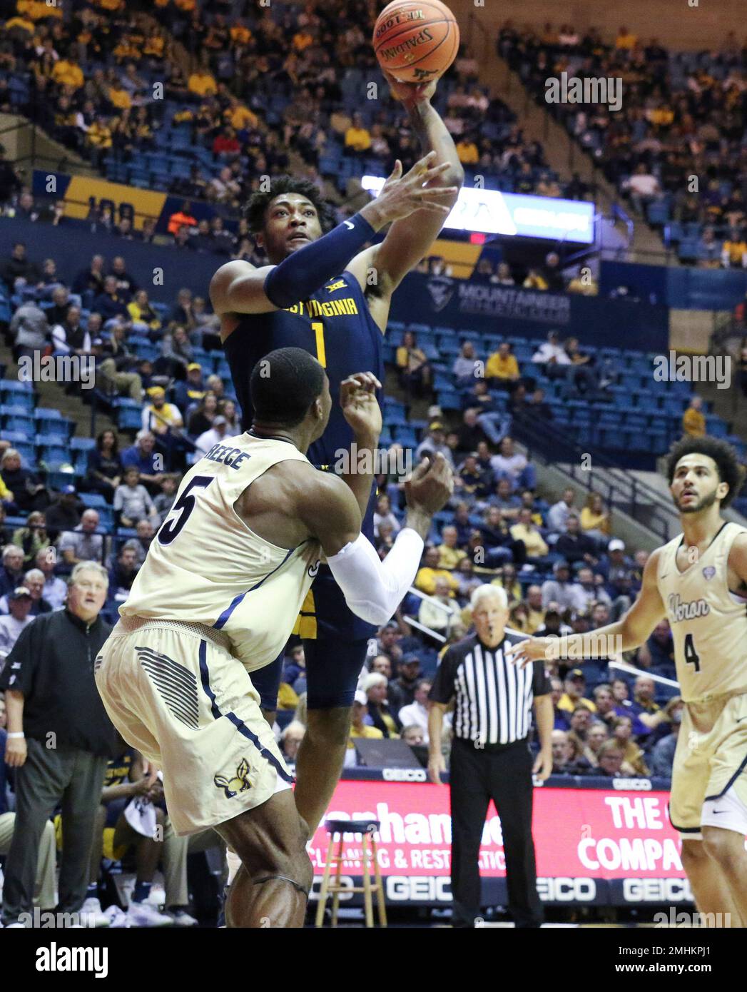 West Virginia's Derek Culver shoots over Akron's Camron Reece during an ...