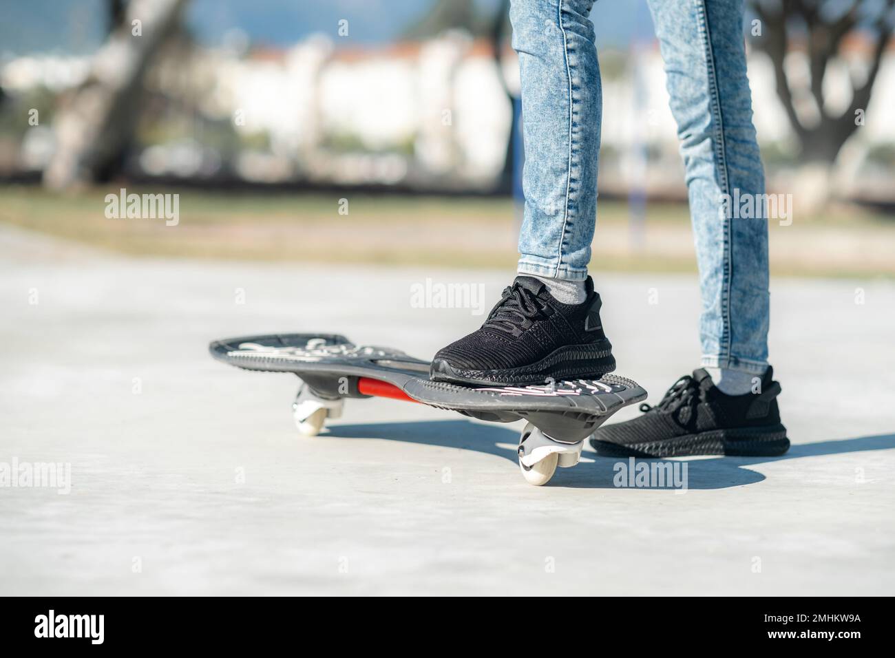 Legs on waveboard close up, Girl riding on casterboard with two wheels ...