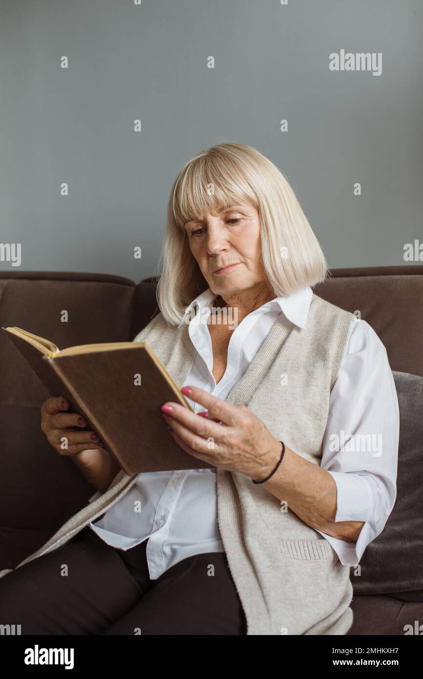 Senior caucasian woman at home reading book sitting alone Stock Photo ...