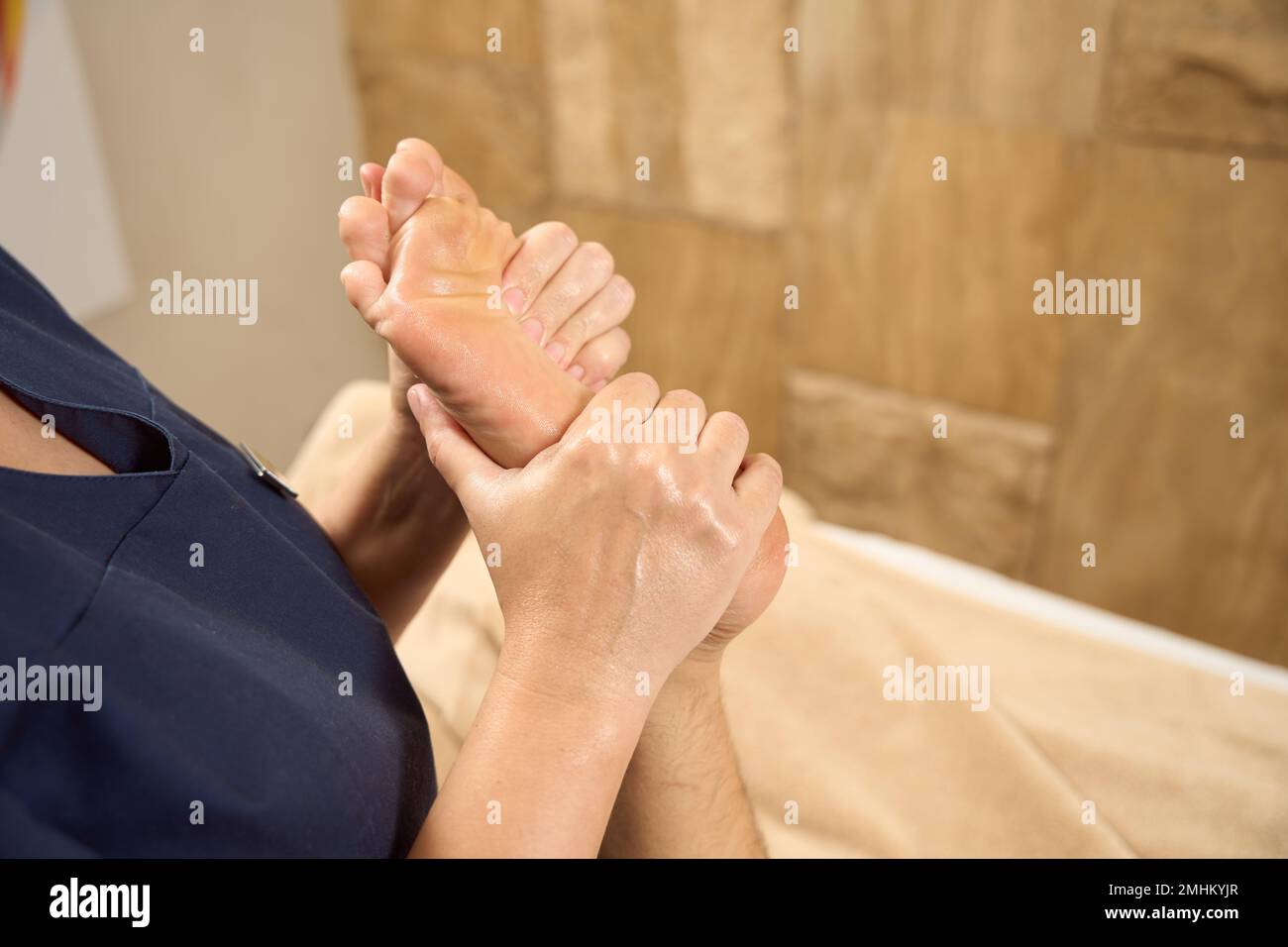 Medical worker kneads the feet of a client medical center Stock Photo ...