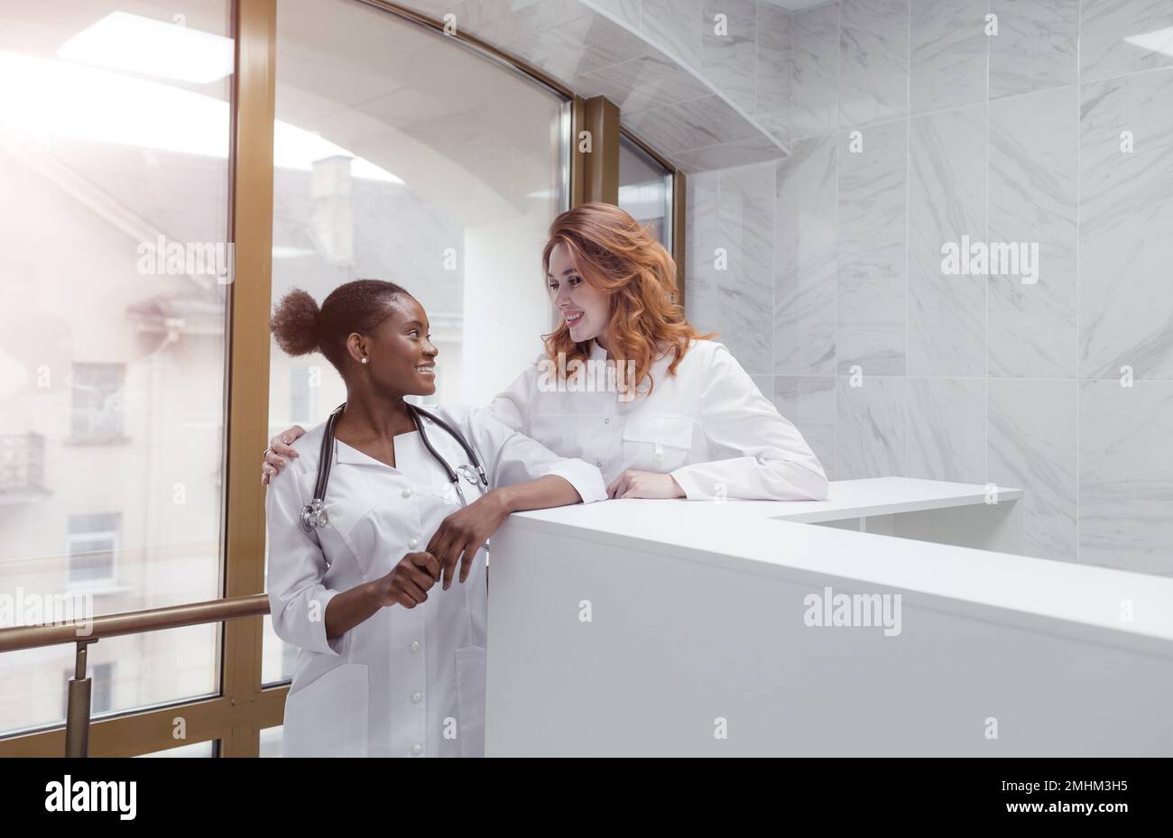 female hospital doctors communicate with each other near the reception ...