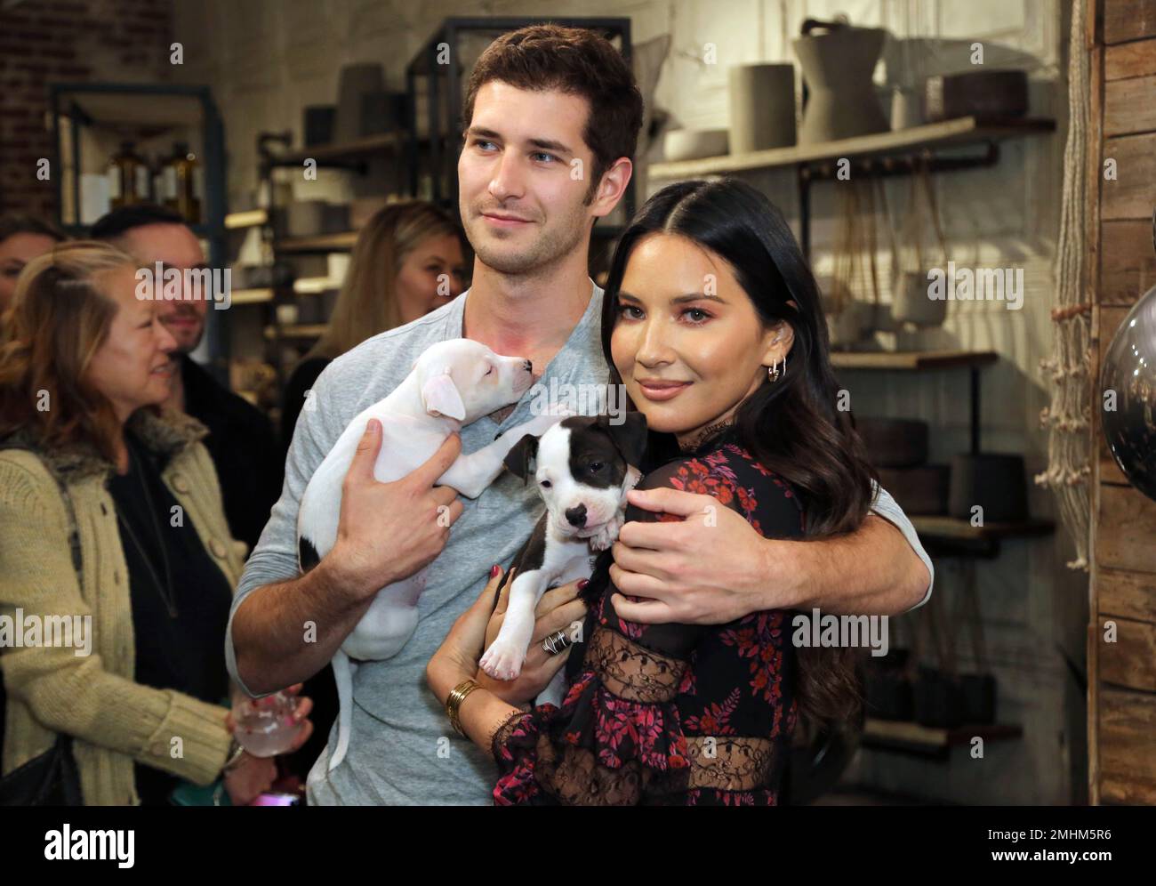 Tucker Roberts, left, and Olivia Munn hold two puppies as they arrive ...
